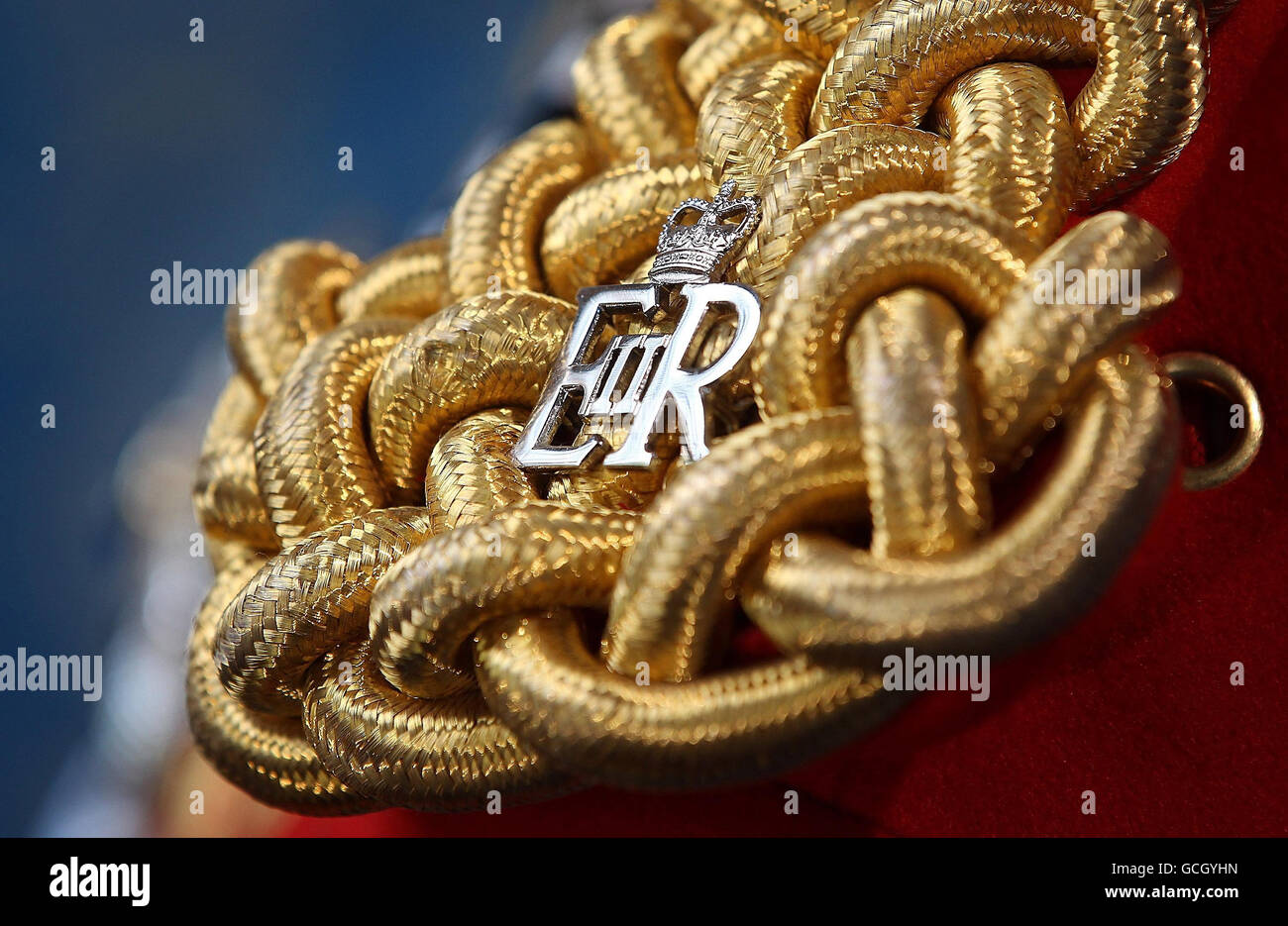 The Royal Cypher, is displayed on the shoulder of an official during ...