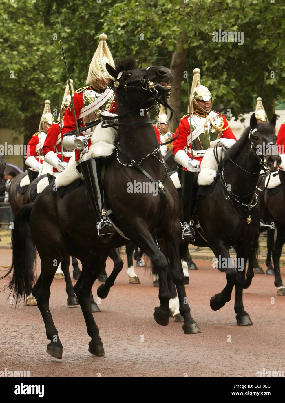 A member of the Household Cavalry controls his rearing horse as troops ...