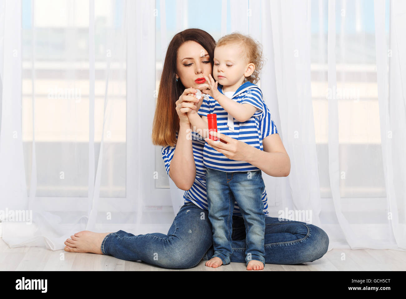 Young mother and baby daughter inflate soap bubbles. Mother and ...