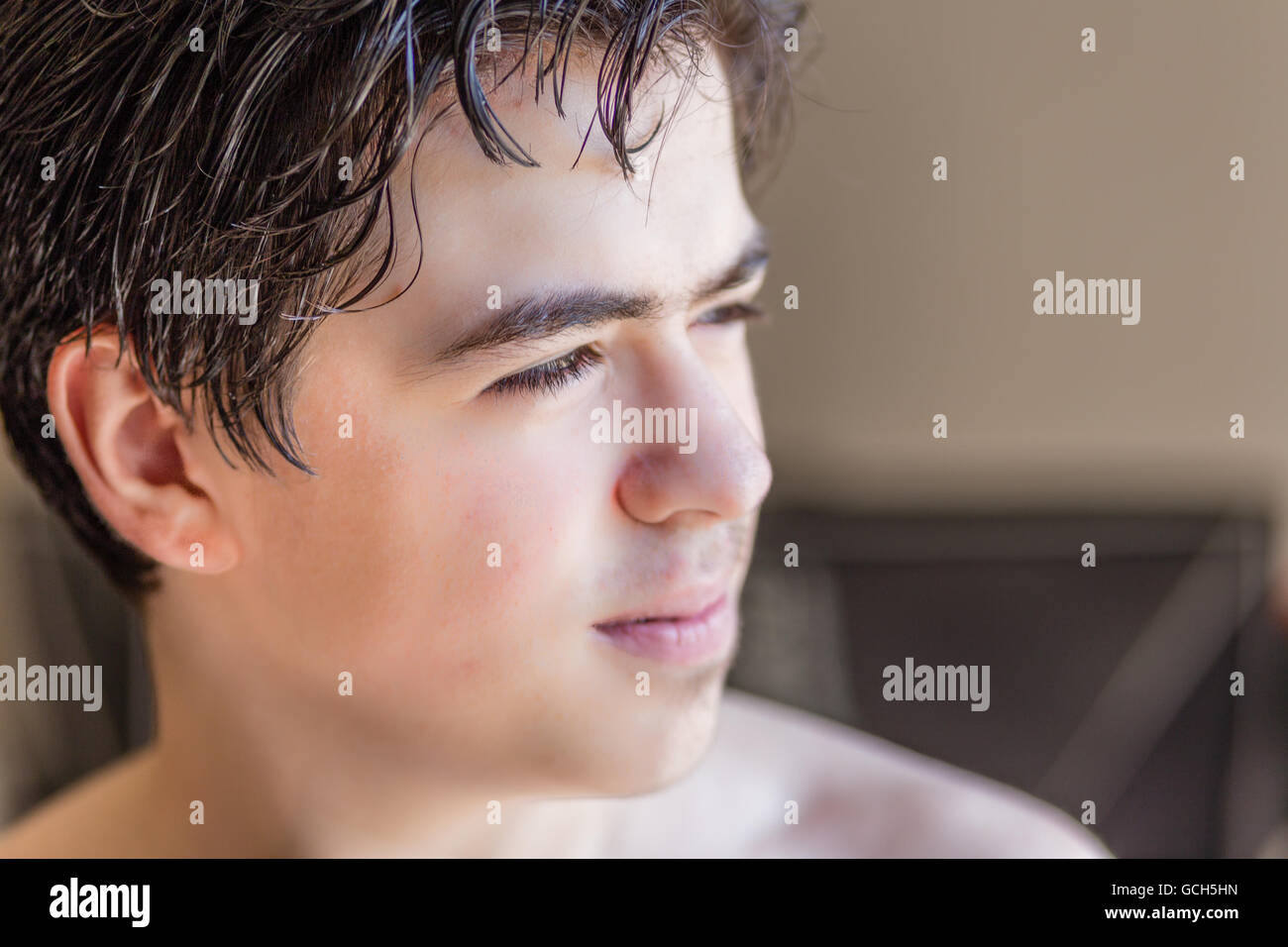 close up of sideview of face of young teen boy in profile in interiors ...