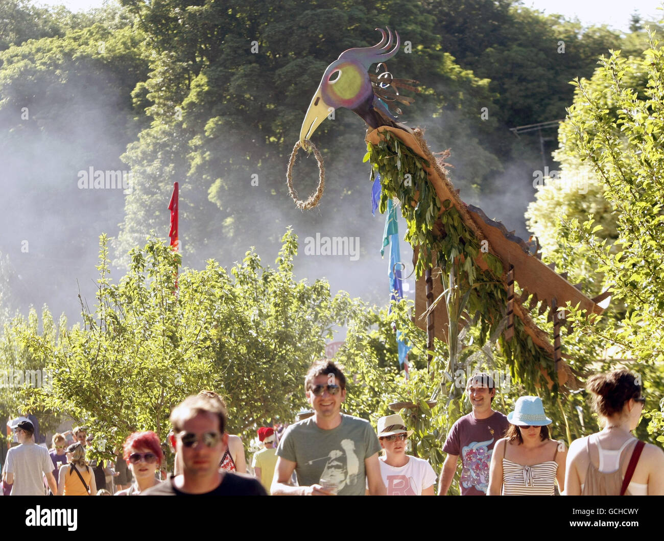 A giant Phoenix sculpture stands over revellers before being set on ...