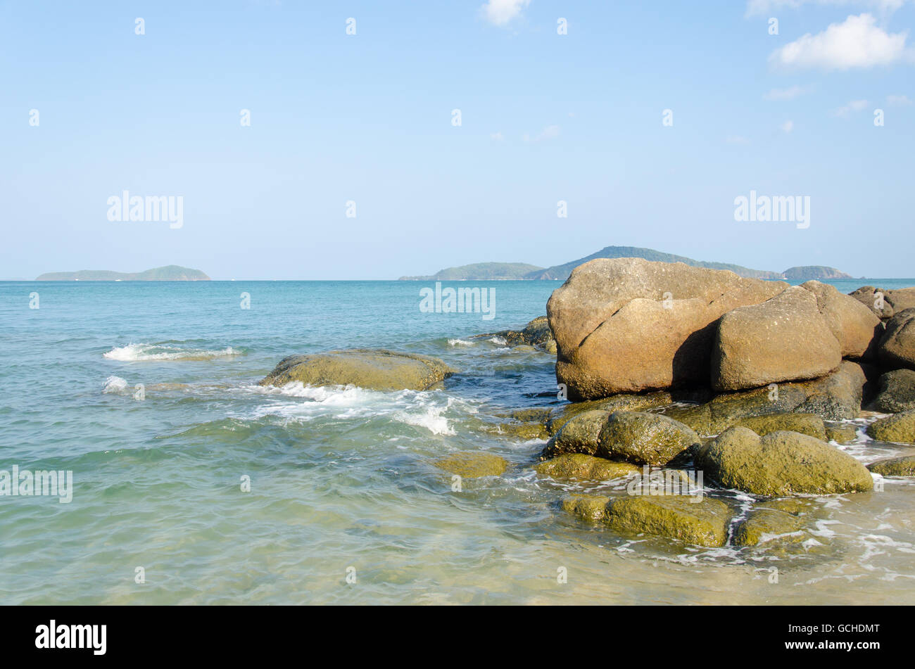 Stone in sea with wave on sunset time Stock Photo - Alamy