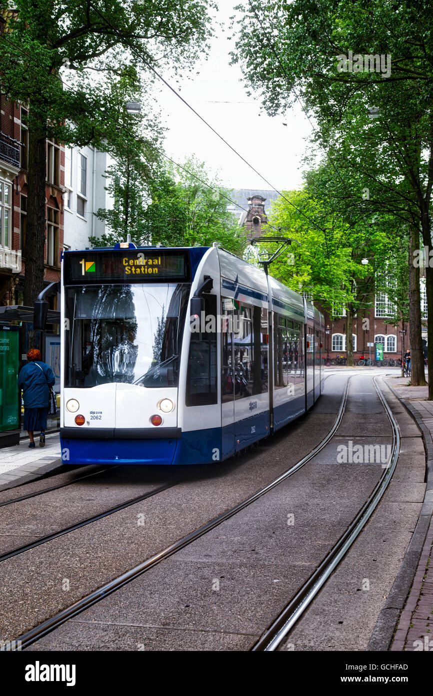 A light rail train on the tracks on a street; Amsterdam, Netherlands ...