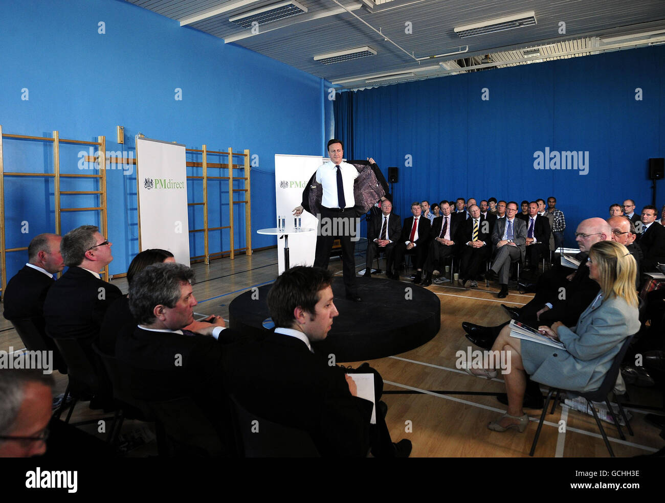 Prime Minister David Cameron removes his suit jacket as he begins his ...