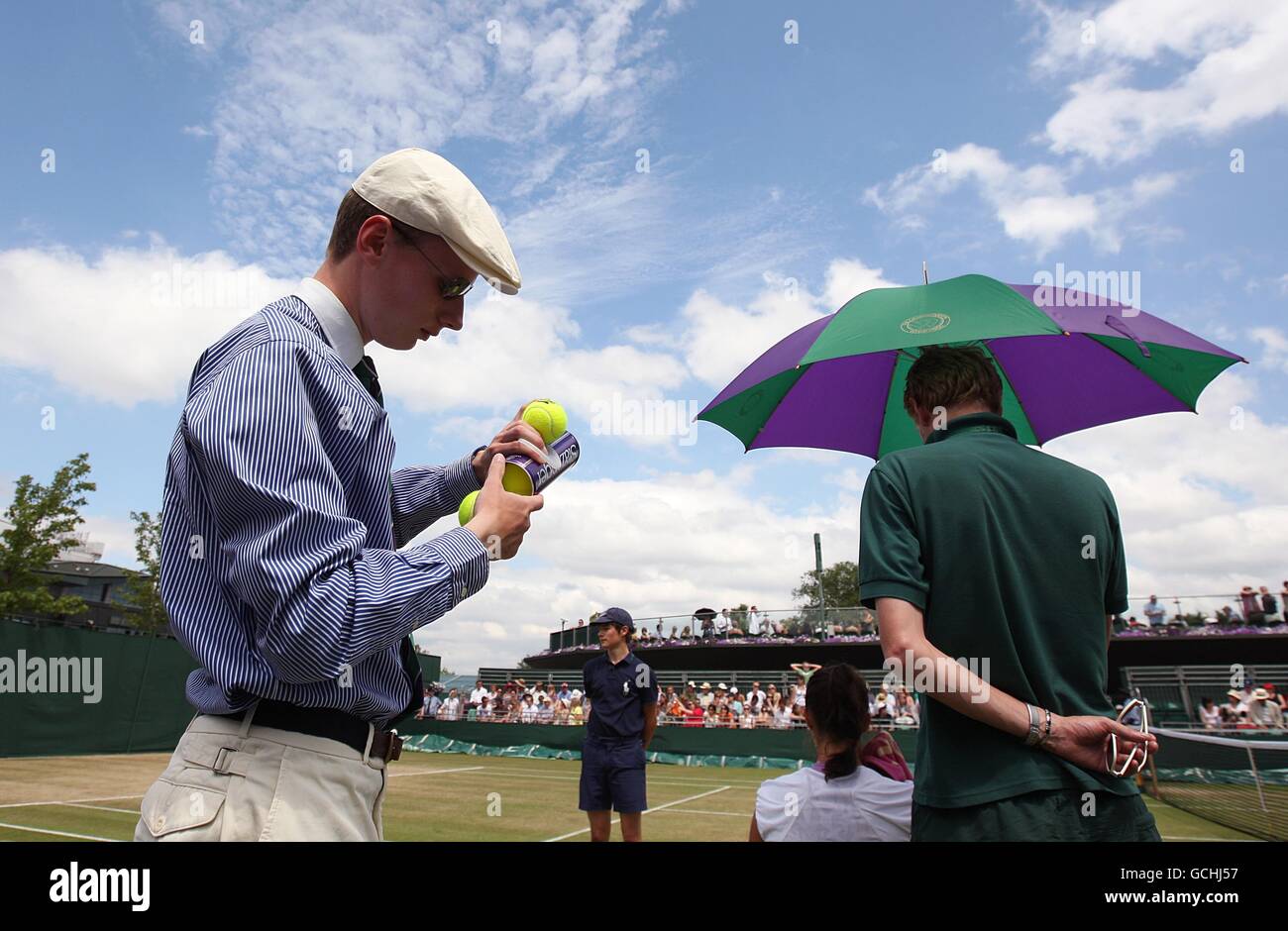 A line judge (left) prepares the tennis balls prior to the match ...
