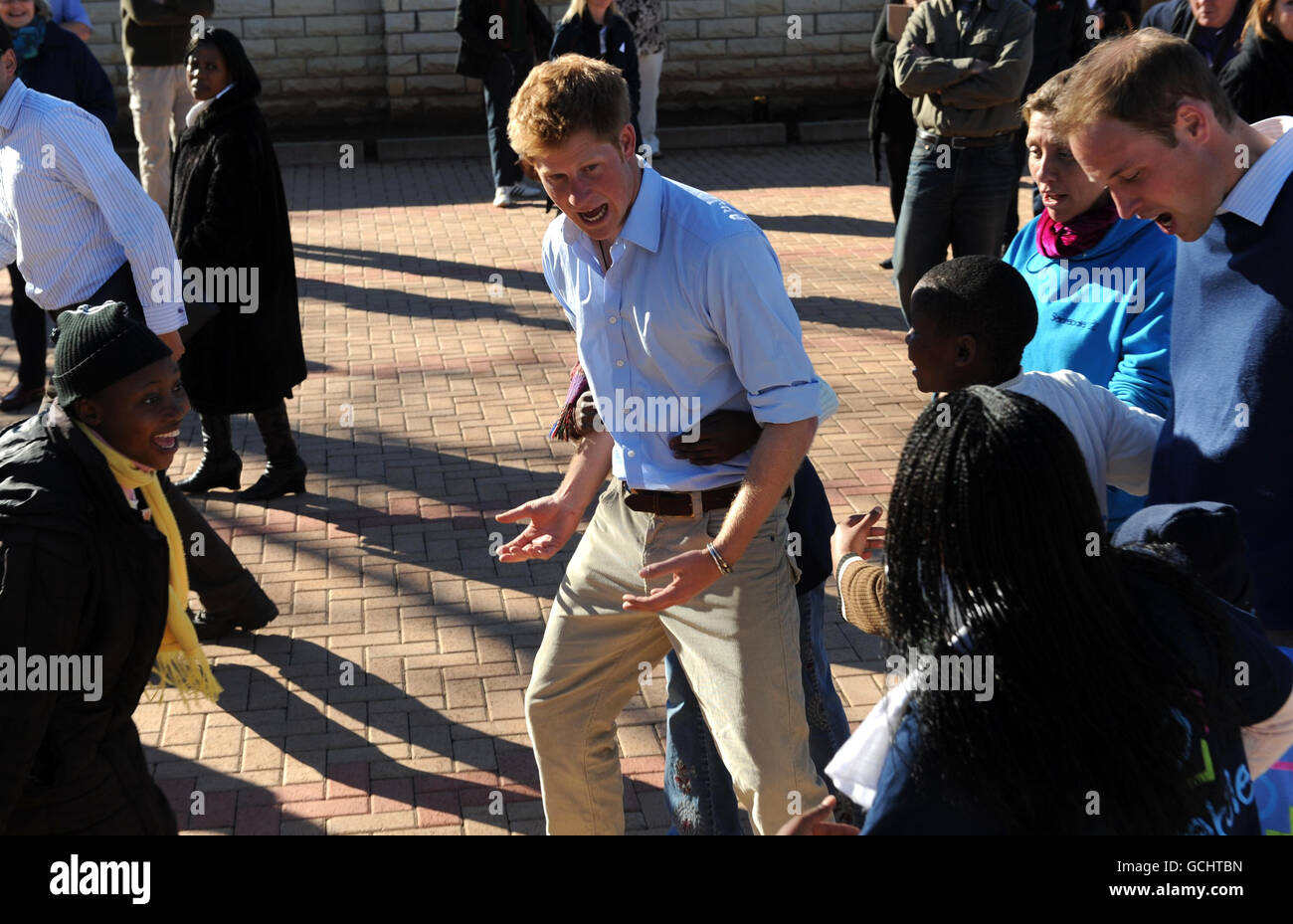 Prince William (right) and Prince Harry play with children during a ...