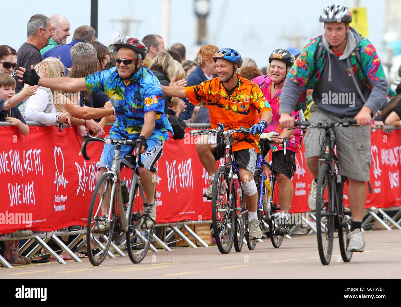 Riders greet the crowd as they cross the finishing line in Brighton ...