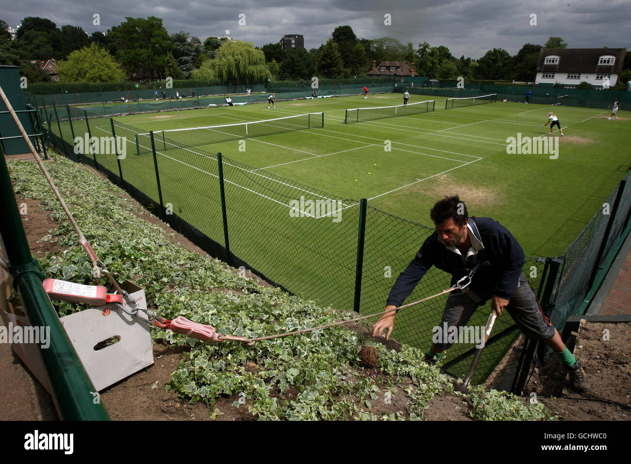 A worker prepares the gardens next to the practice courts during a ...