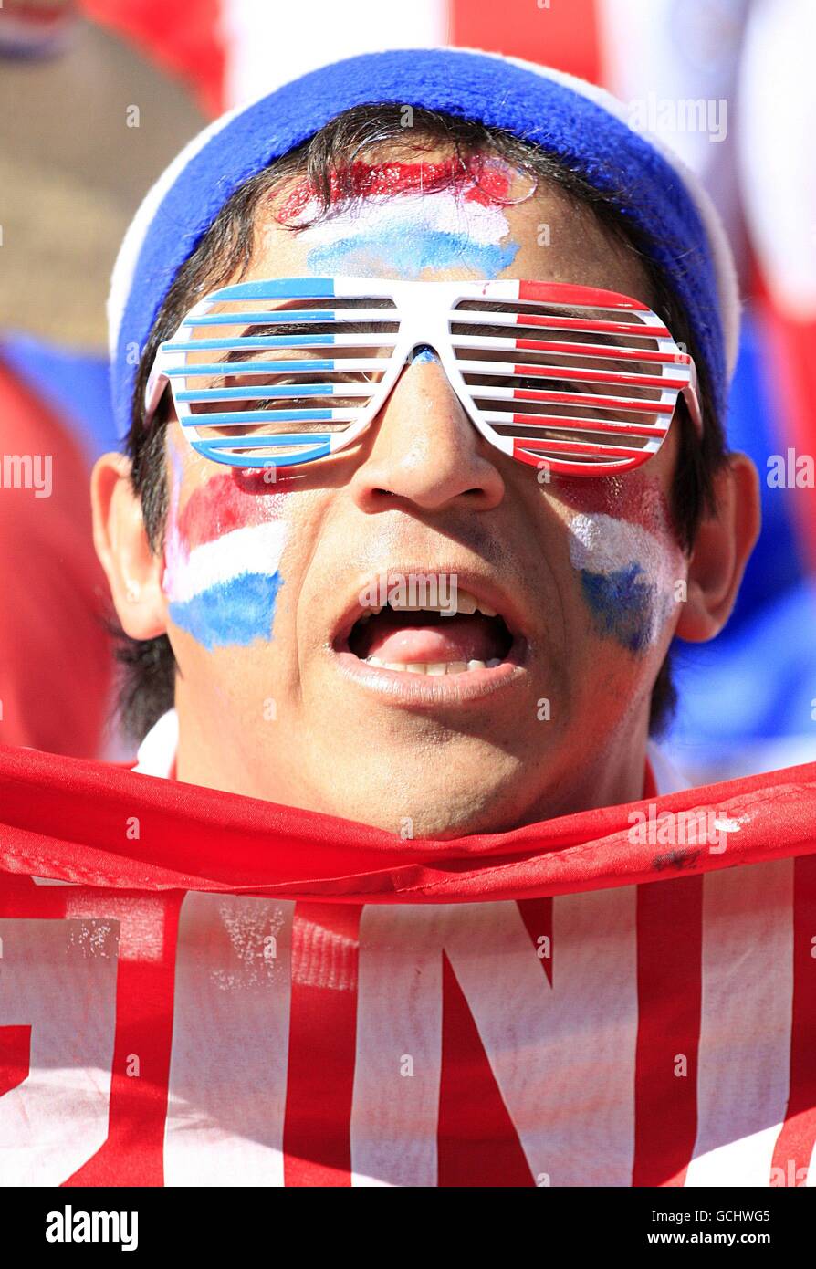 A Paraguay fan shows his support in the stands with a painted face and ...