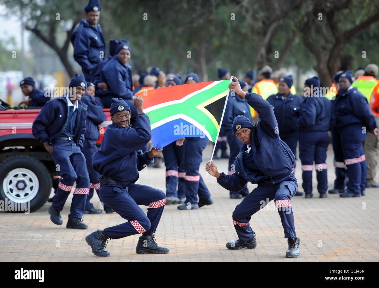 Police officers wave a South African flag following a passing out ...
