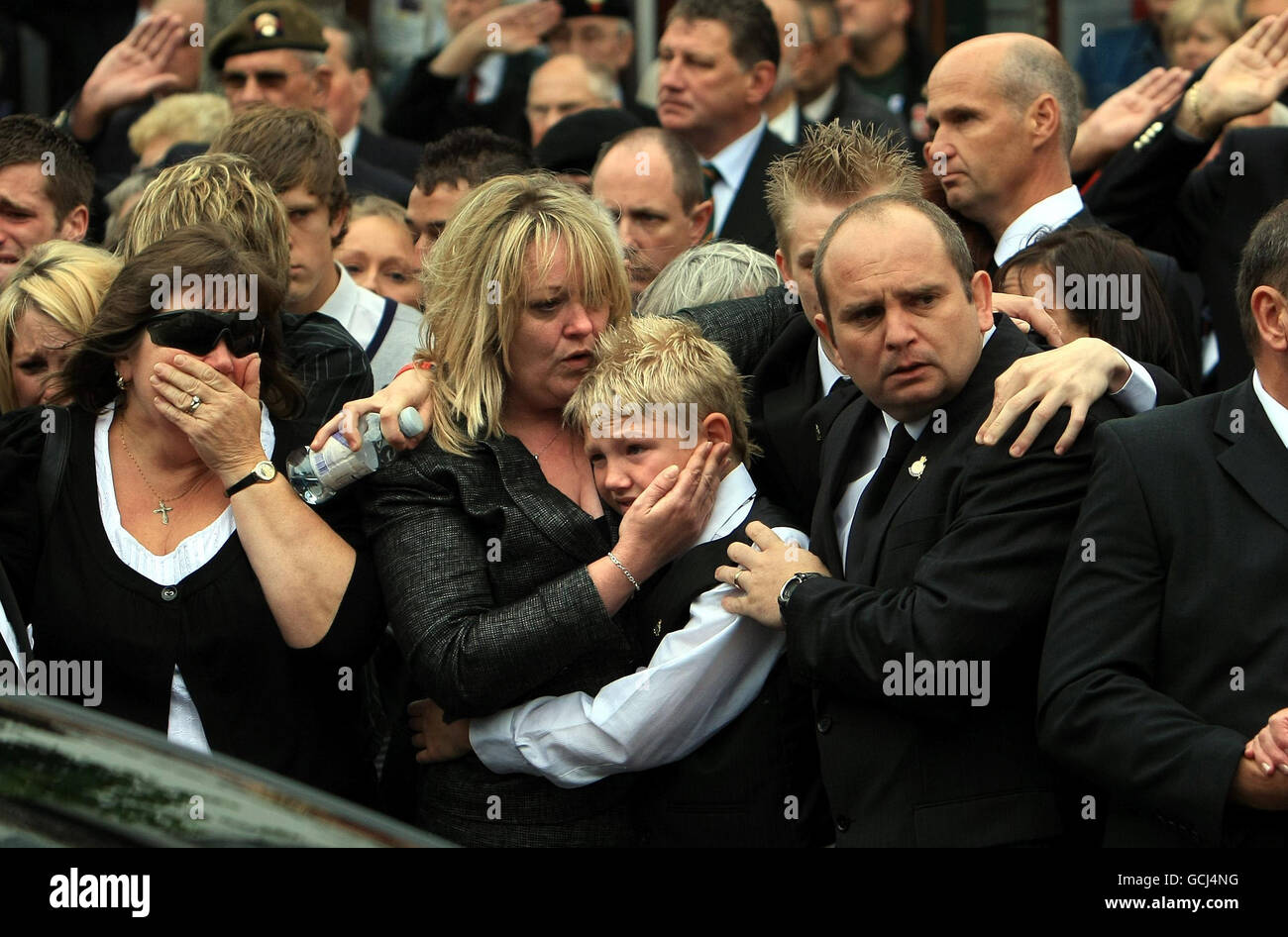 Nicola Hotine (centre), mother of Marine Anthony Hotine, 21, hugs her ...