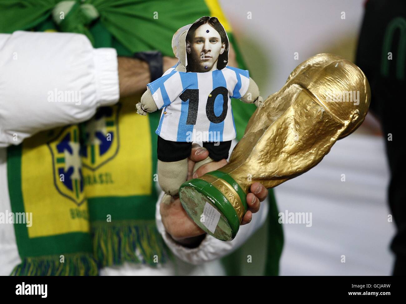 A Brazil fan in the stands with a voodoo doll of Lionel Messi and a ...