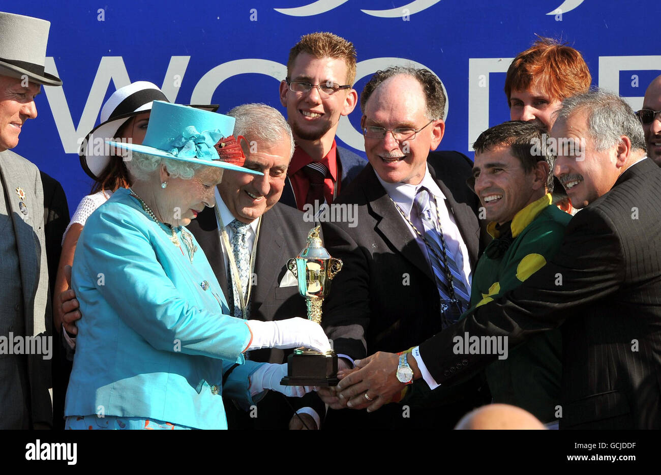 Britain's Queen Elizabeth II presents the winner's trophy to jockey ...