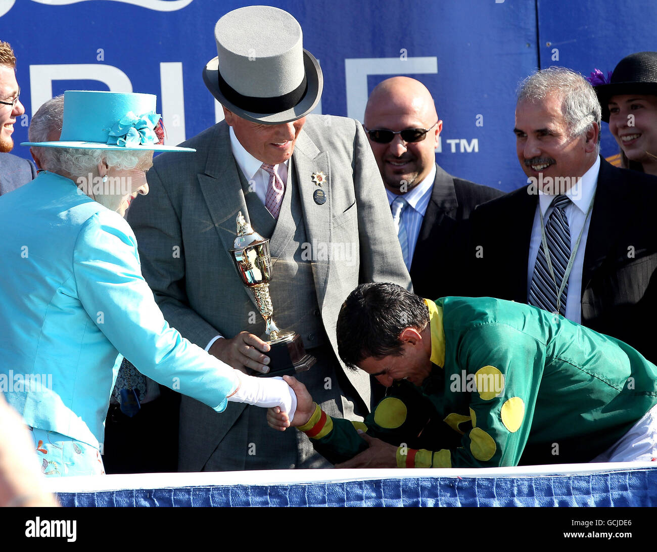 Britain's Queen Elizabeth II presents the winner's trophy to jockey ...