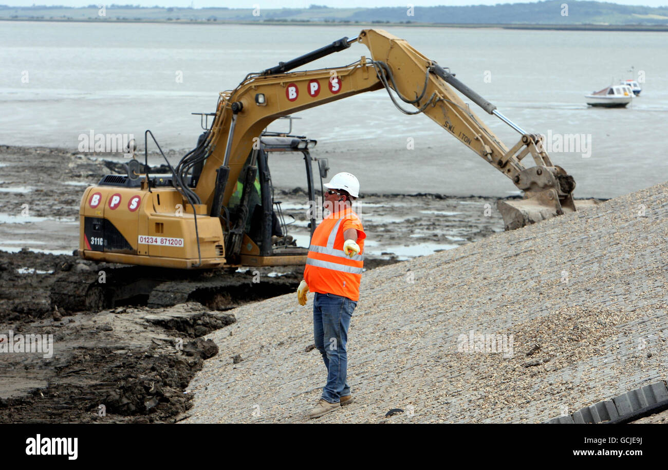 Construction workers carry out works ahead of the high tide along the ...