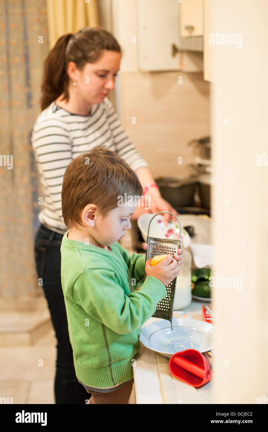 little son helps mother cook in the kitchen Stock Photo - Alamy