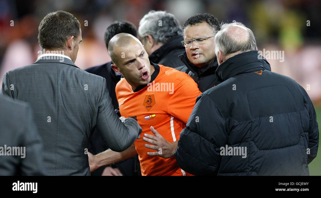 Netherlands' Johnny Heitinga has to be led away by his coaching staff ...