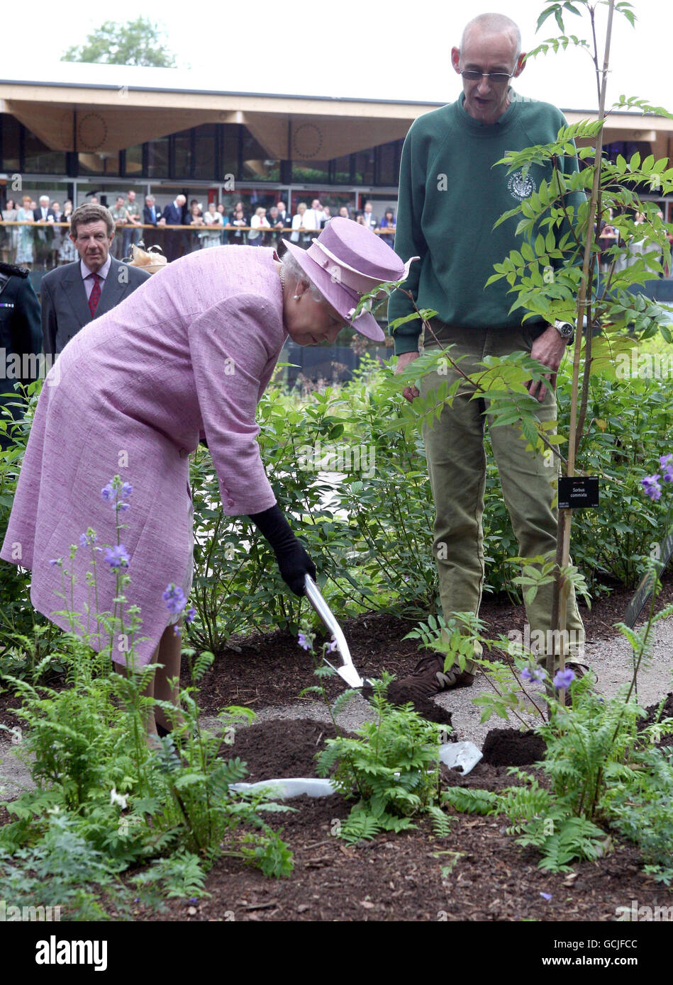 Britain's Queen Elizabeth II plants a tree as she officially opens a ...