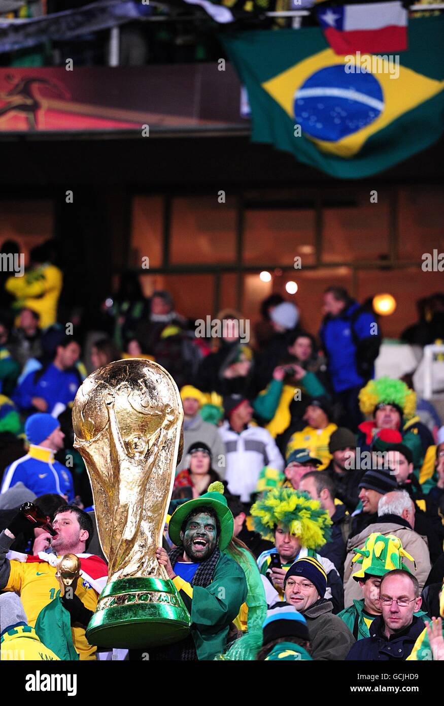 A Brazil fan with a model of the world cup trophy in the stands prior ...