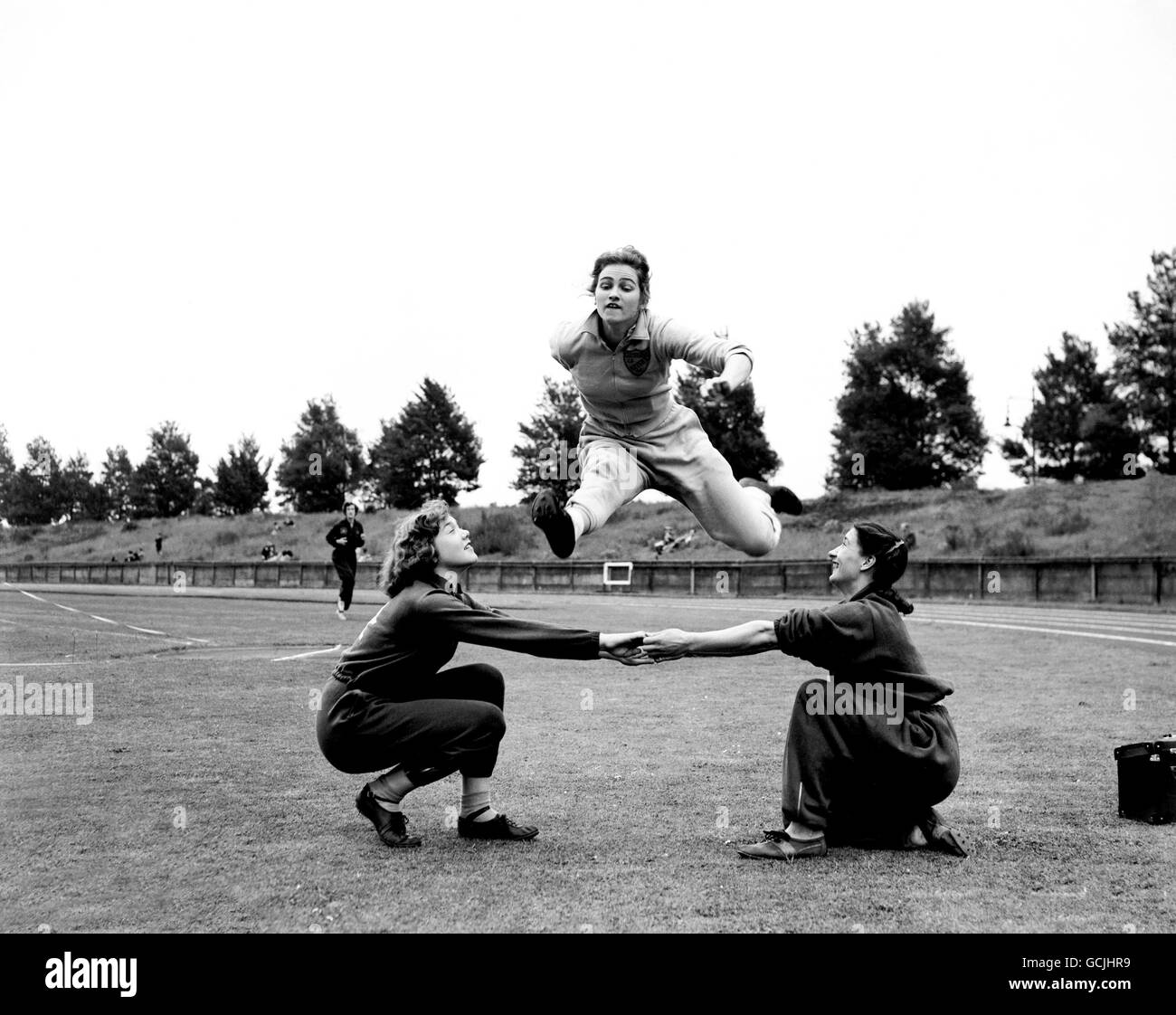 Janis long jumps over her team mates arms l r Black and White Stock ...