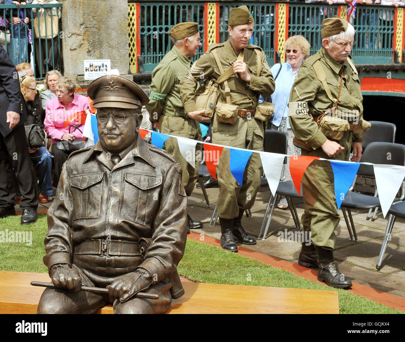 A group of men dressed as the Home Guard of 1940's Britain, walk past a ...