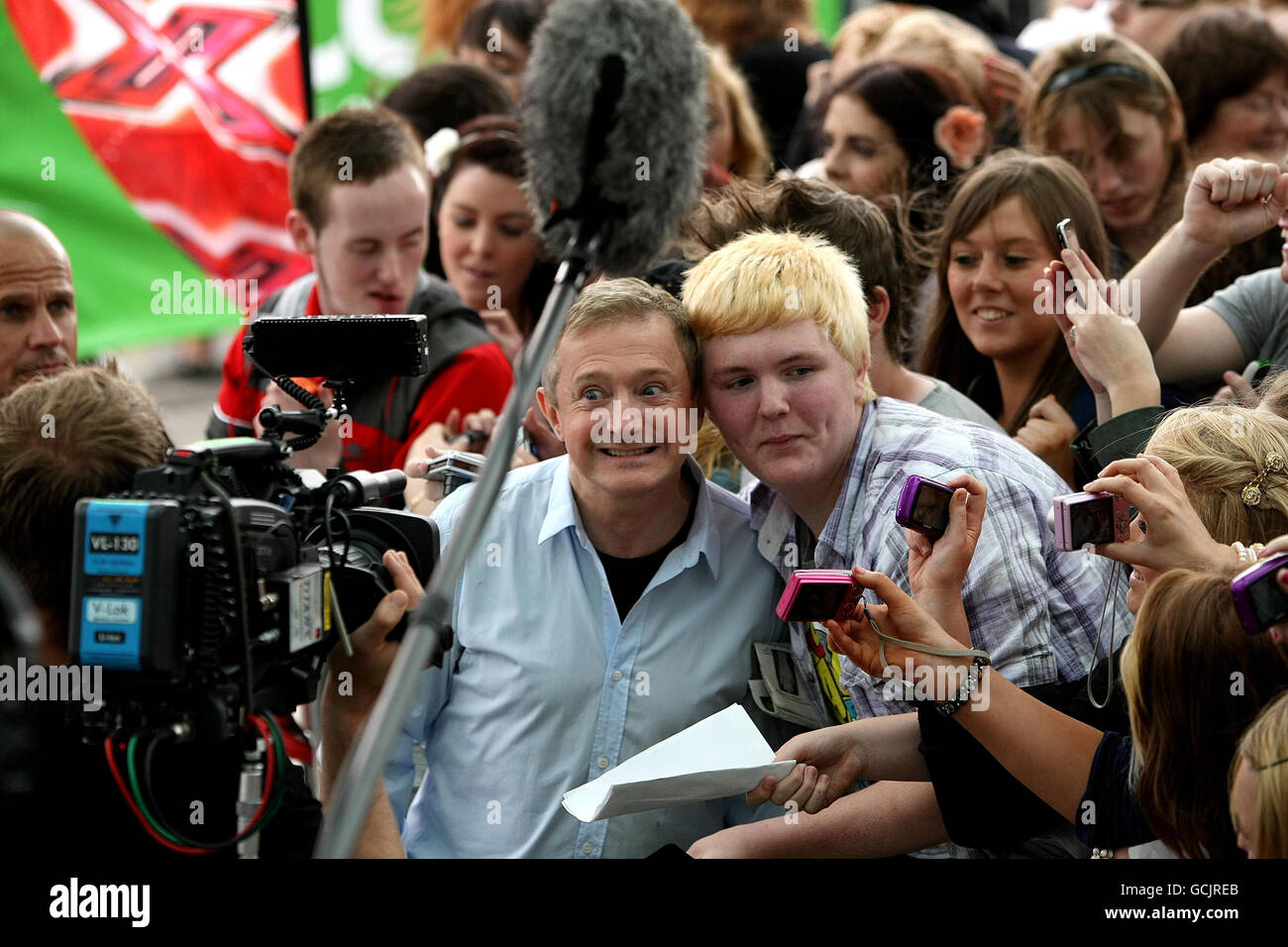 X-Factor judge Louis Walsh has his picture taken with fans outside the ...