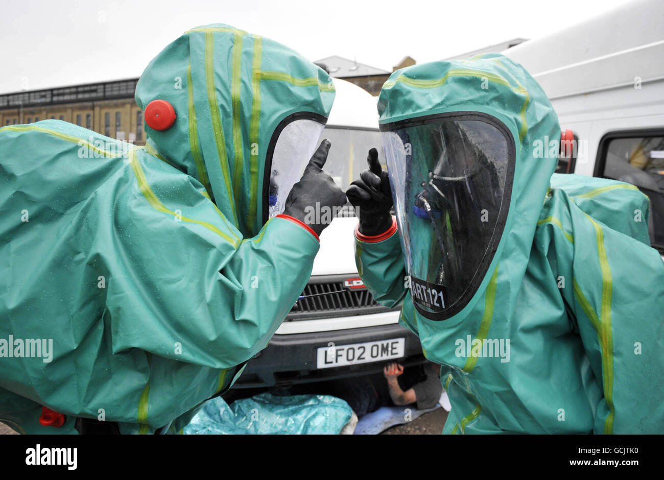 Firefighters and NHS staff wearing gas tight suits try to communicate ...