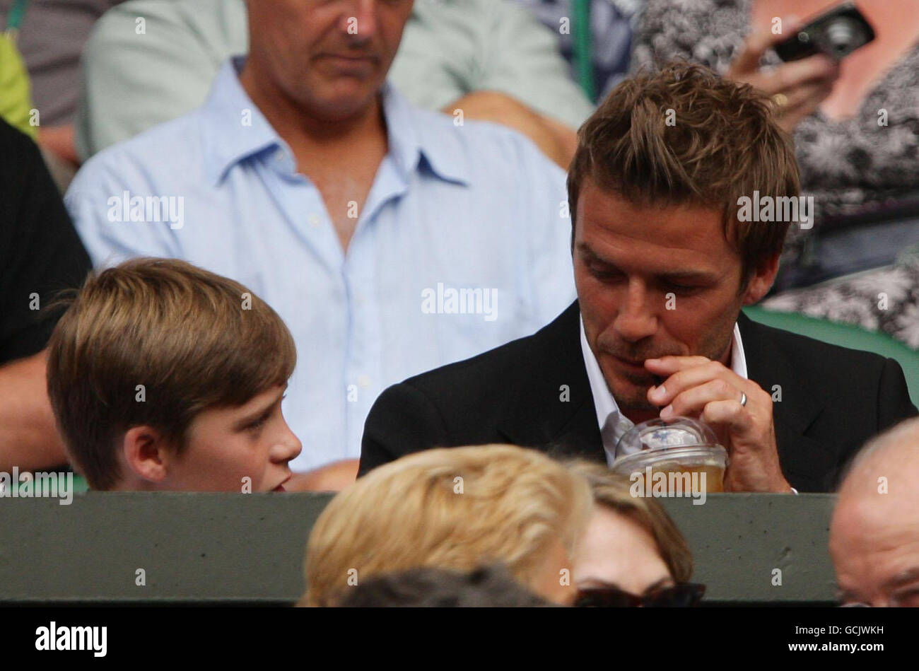 David Beckham takes a drink as he watches Great Britain's Andy Murray ...