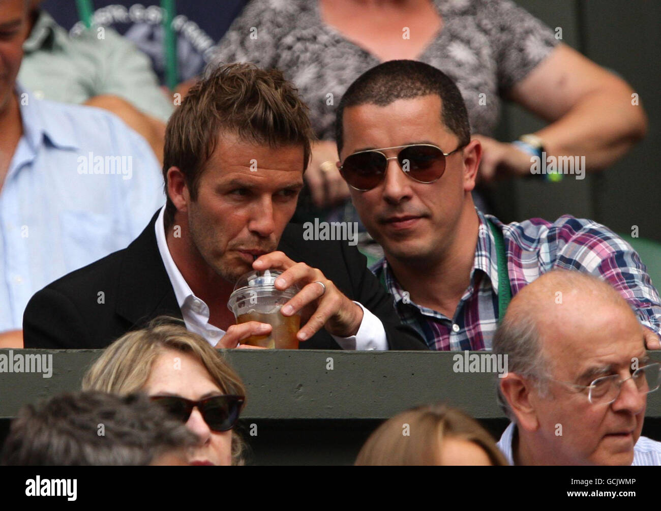 David Beckham takes a drink as he watches Great Britain's Andy Murray ...