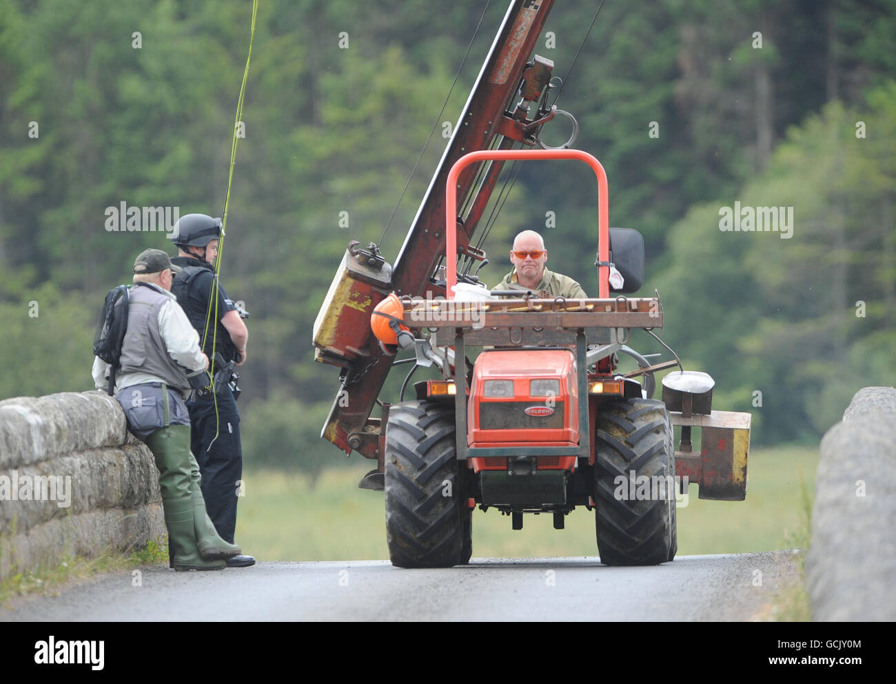 An arrmed police officer guards a bridge in the countryside outside ...
