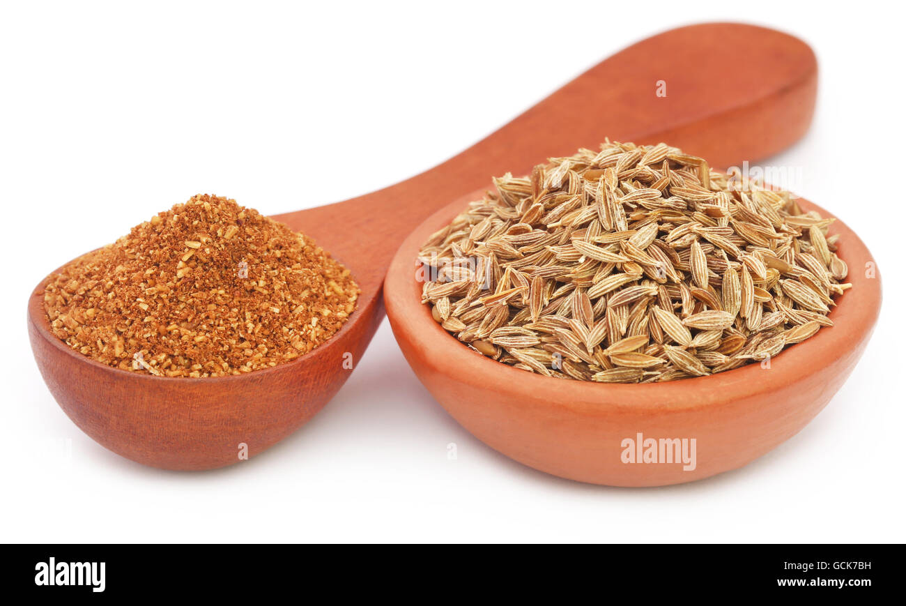 Crushed cumin with whole ones over white background Stock Photo - Alamy
