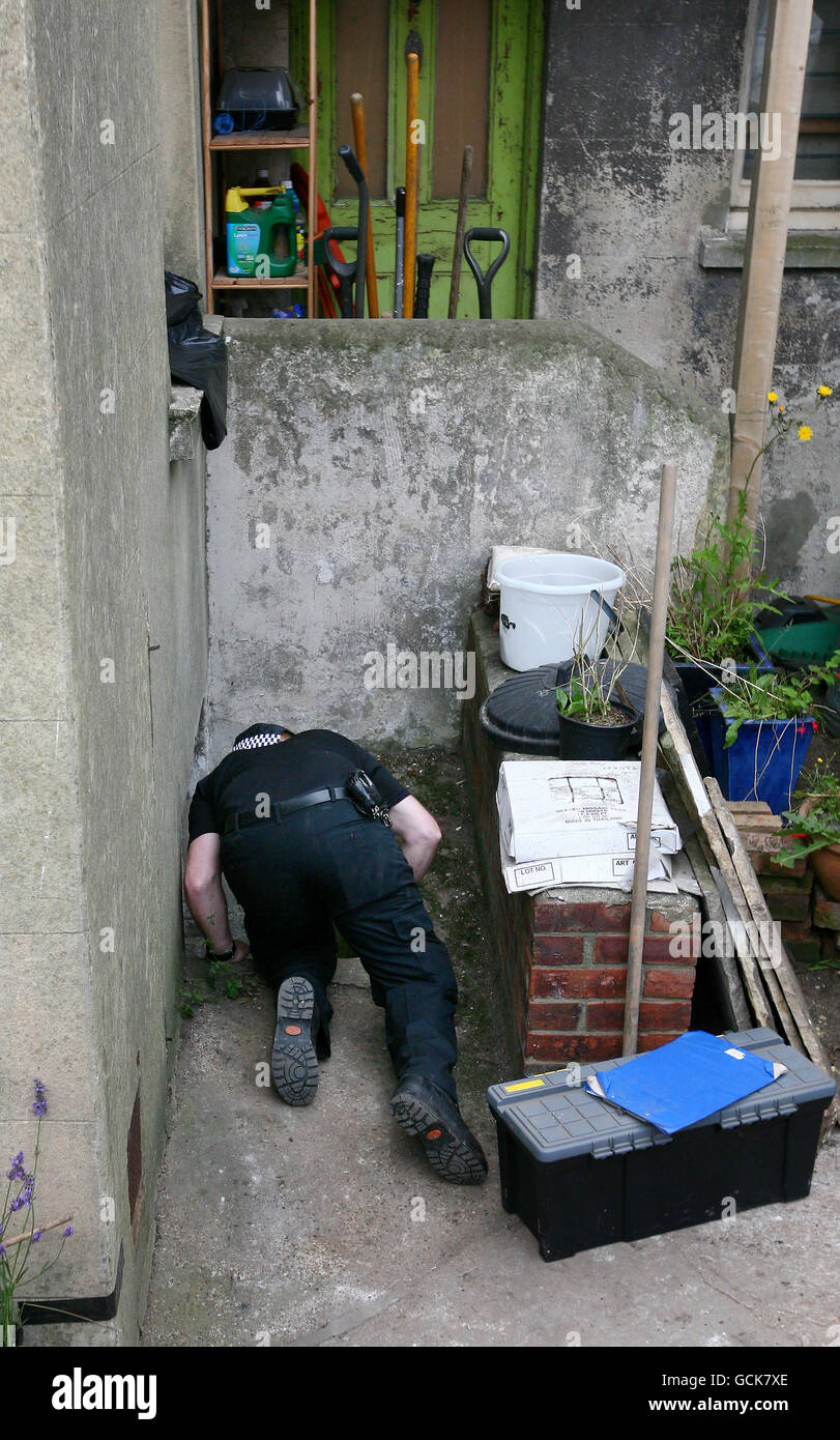 A Sussex Police search officer inspects the entrance to the basement of ...