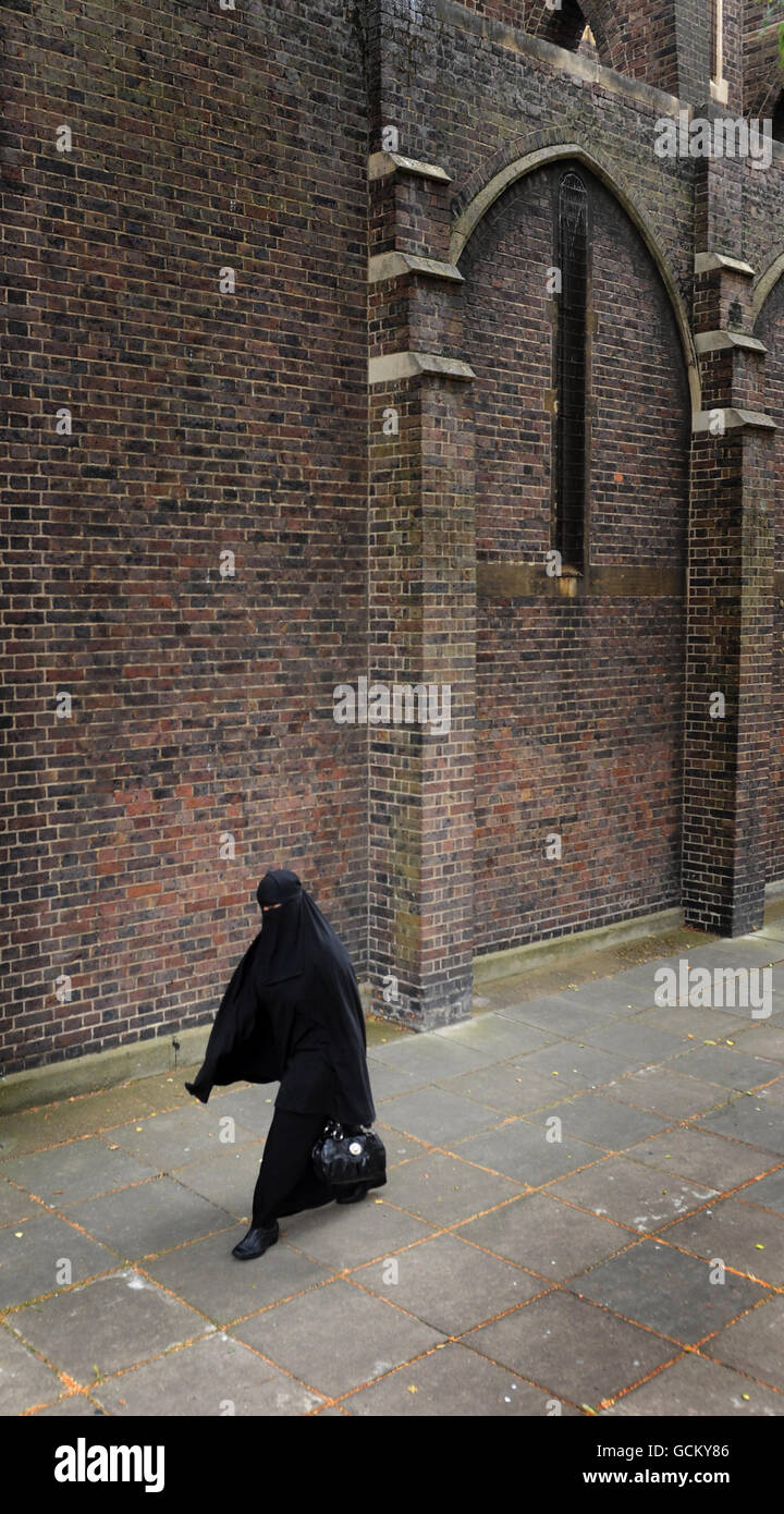 A woman wearing a burqa walks past Saint Silas the Martyr church in ...