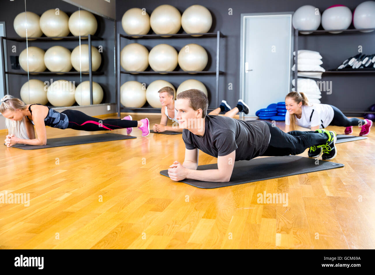 Group of people doing plank at the fitness gym class Stock Photo - Alamy