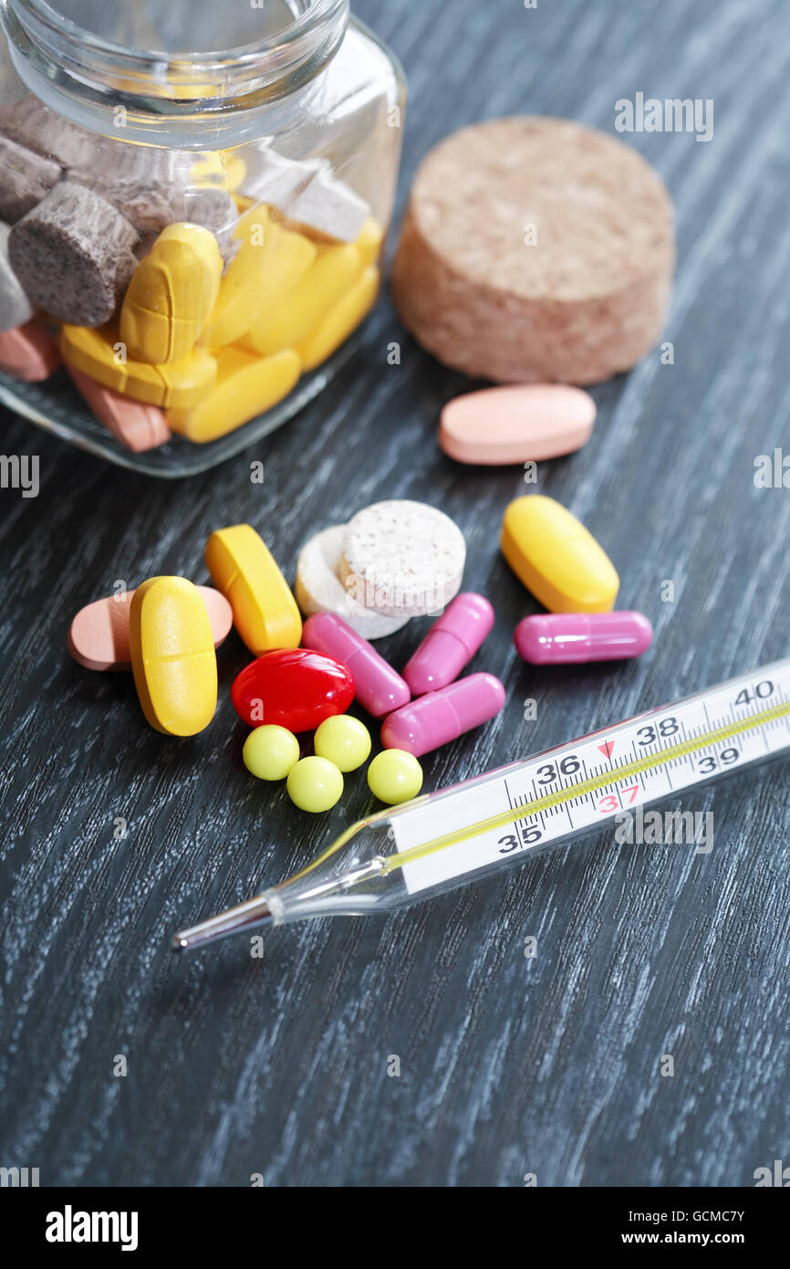 Set of various pills near temperature gauge on wooden table Stock Photo ...