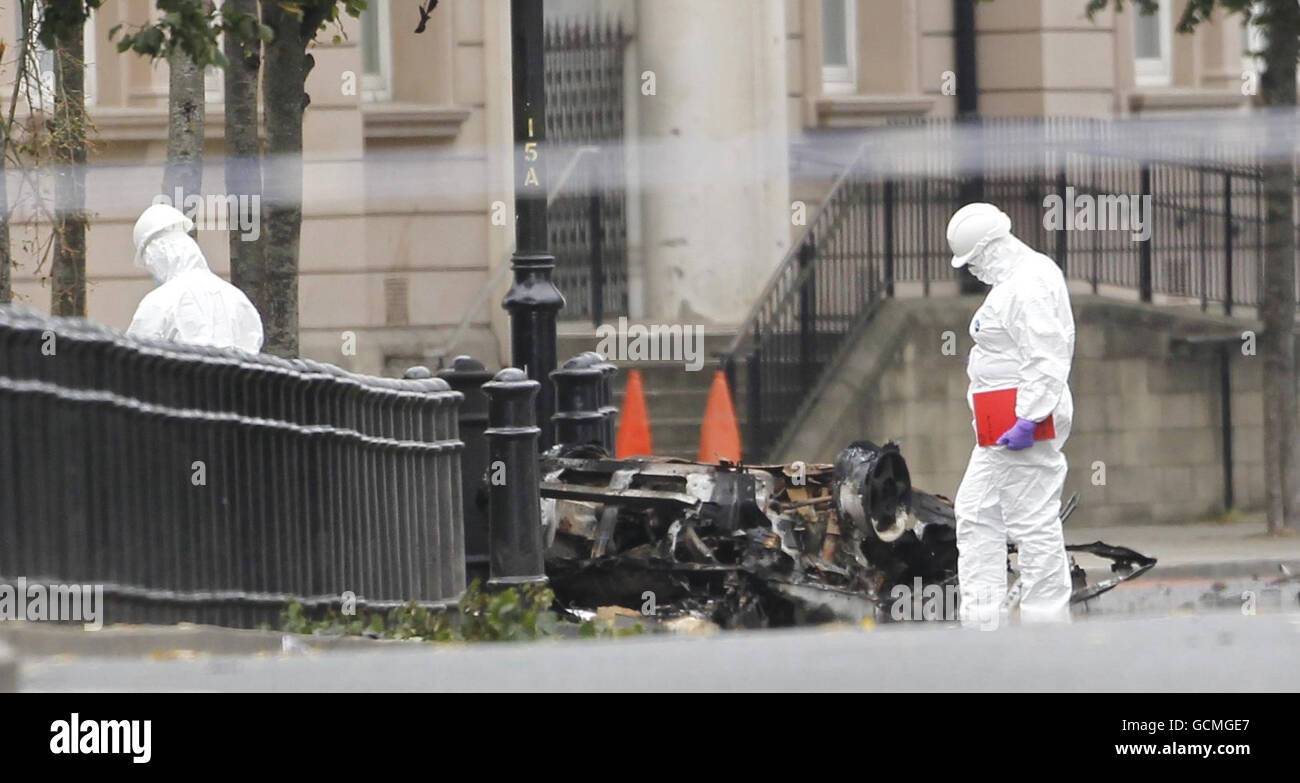 Forensic officers examine the scene where a car bomb exploded outside ...