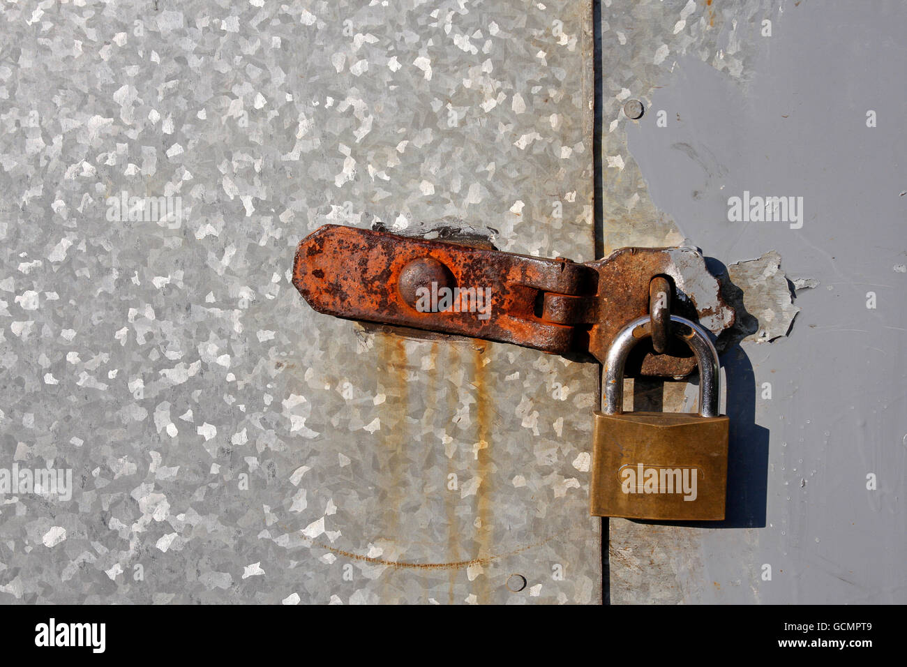 Steel doors securely locked with a rusty padlock Stock Photo - Alamy