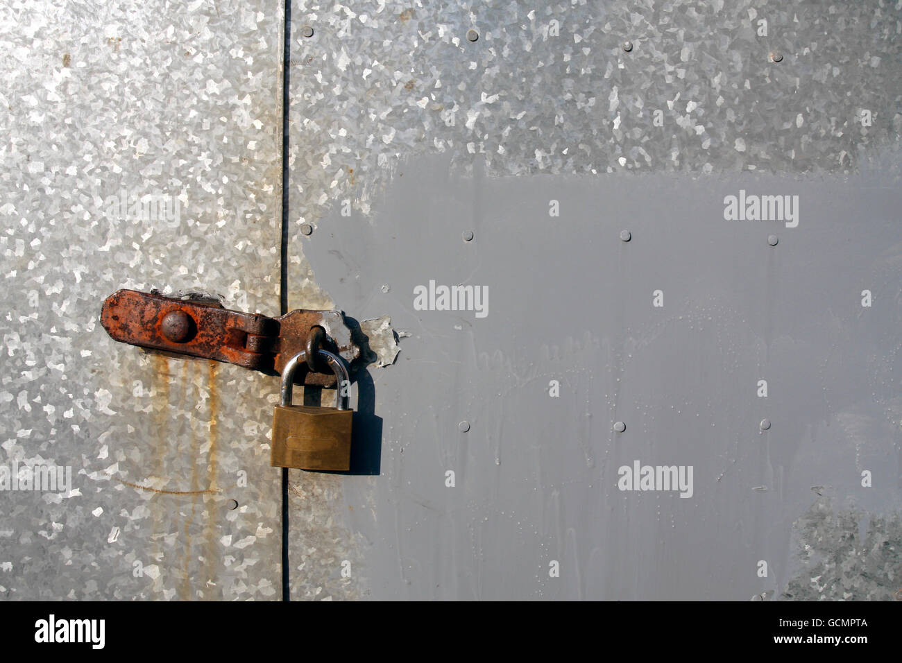Steel doors securely locked with a rusty padlock Stock Photo - Alamy