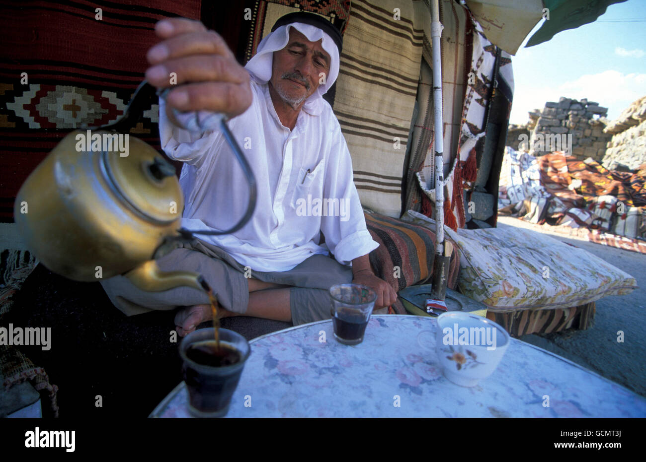 a men with tea in the ruins in the town of Bosra in Syria in the middle ...