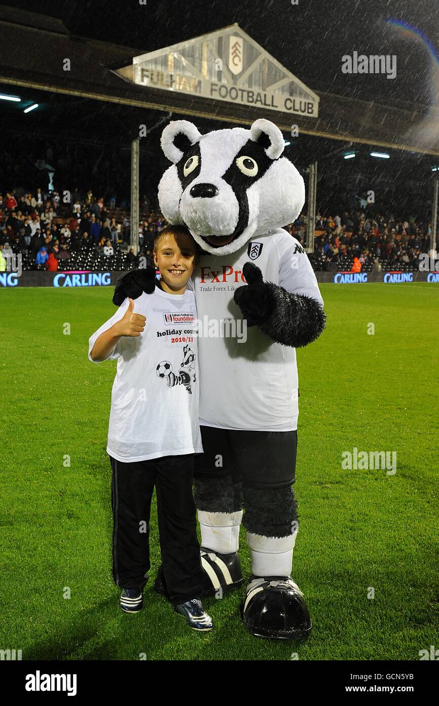 A competition winner poses with Fulham mascot Billy the Badger at half ...