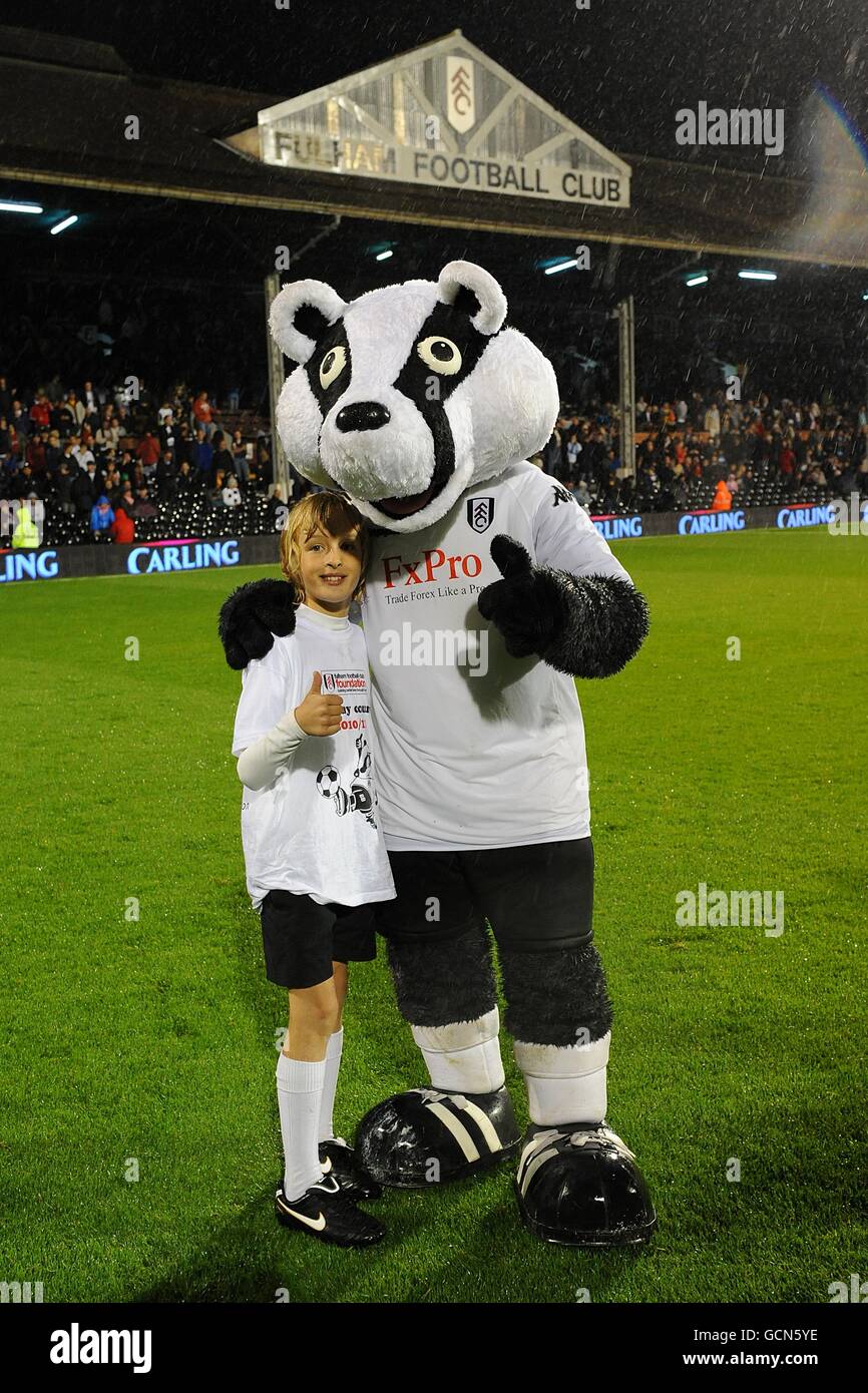 A competition winner poses with Fulham mascot Billy the Badger at half ...