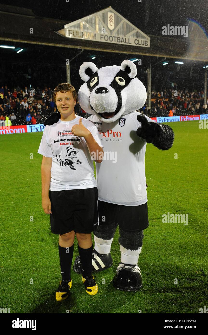 A competition winner poses with Fulham mascot Billy the Badger at half ...