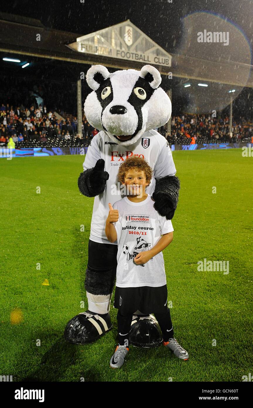 A competition winner poses with Fulham mascot Billy the Badger at half ...