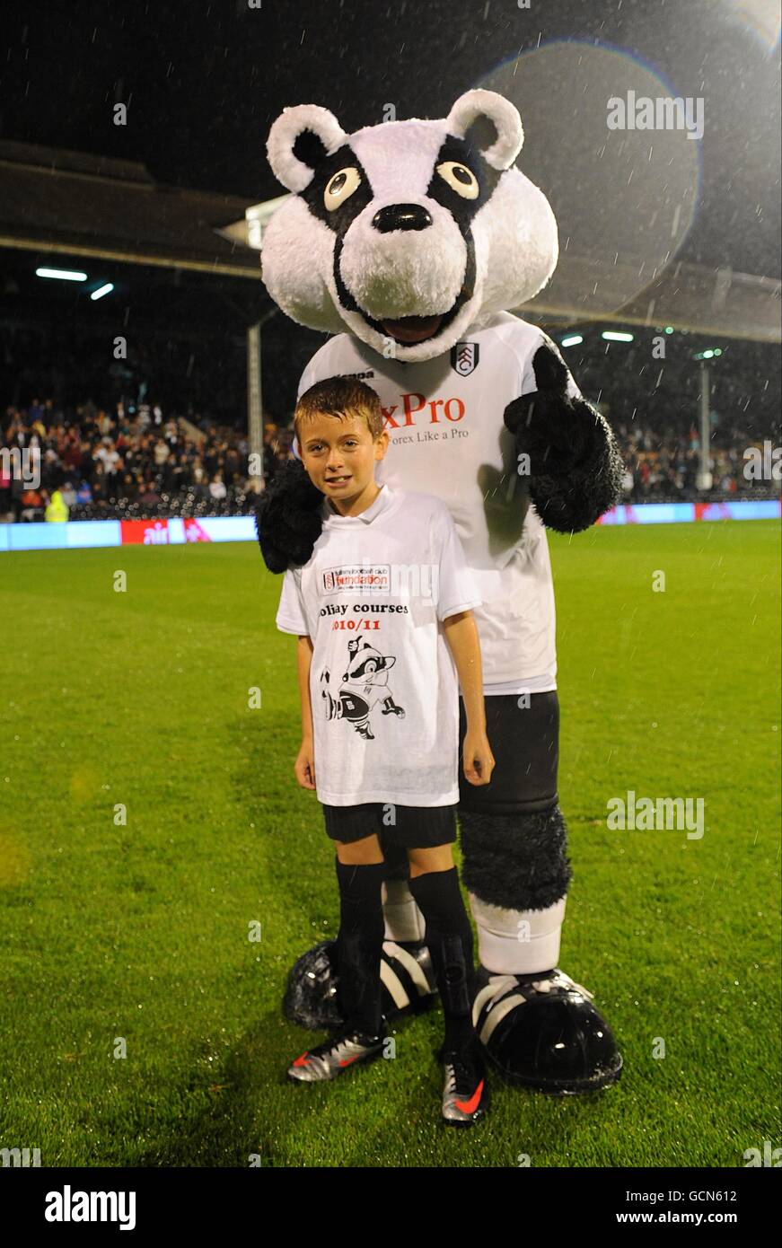 A competition winner poses with Fulham mascot Billy the Badger at half ...