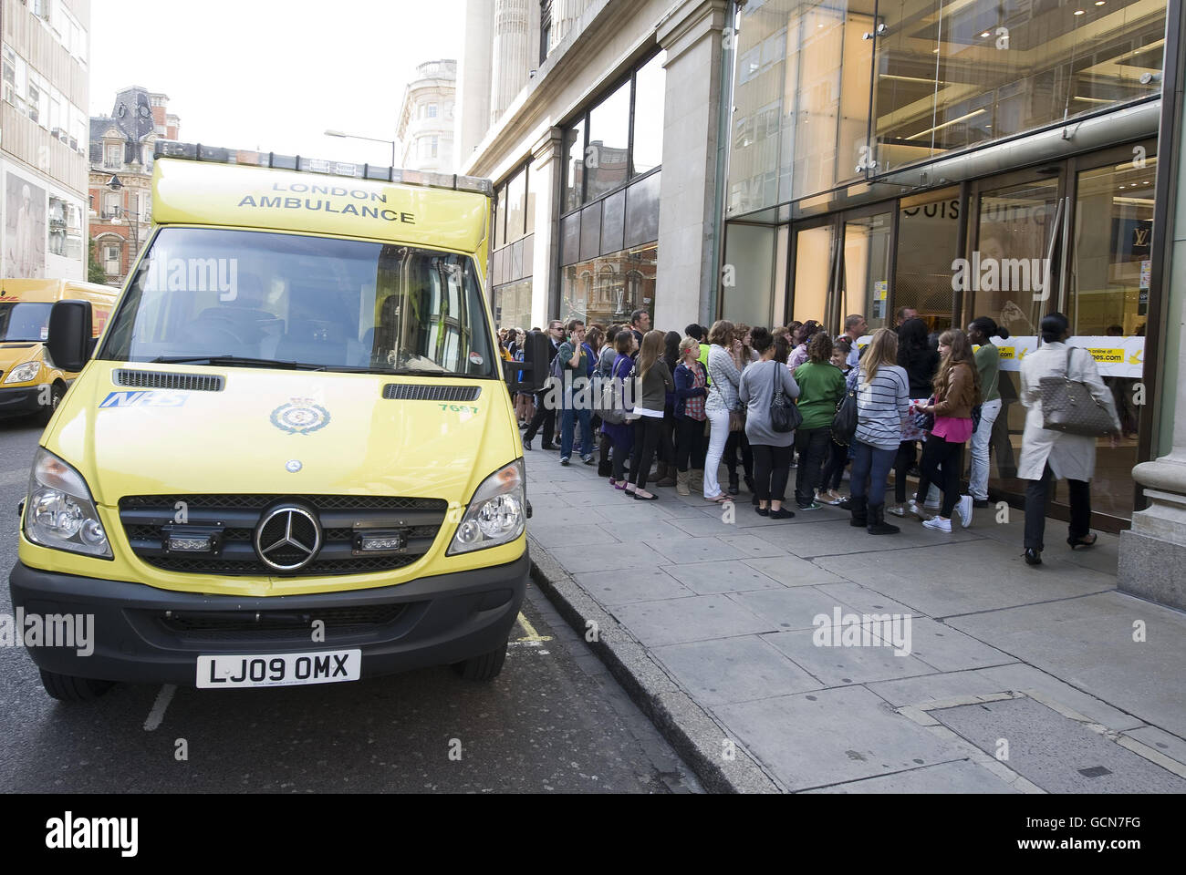 An ambulance by the queue of girls as they wait to meet JLS who will ...