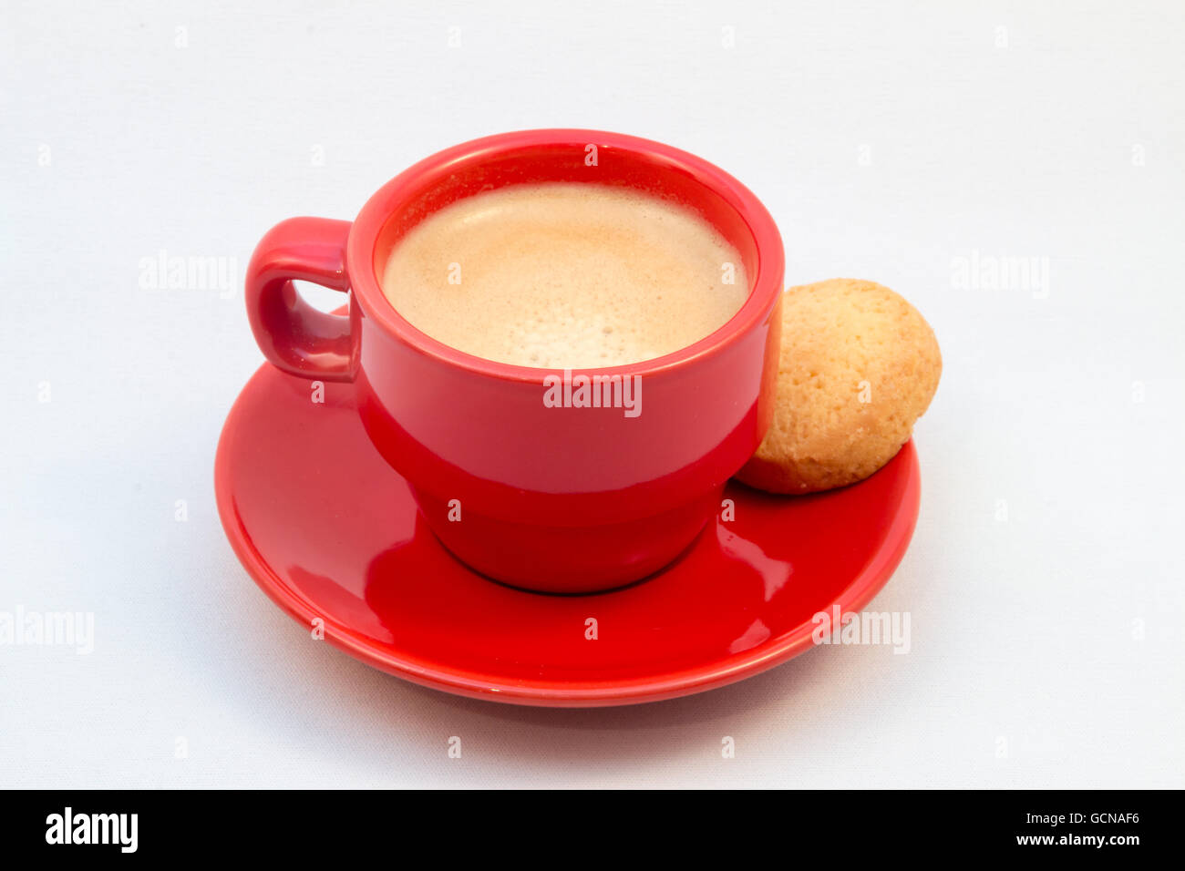 Coffee served with biscuit in a generic red coffee cup on top of a ...
