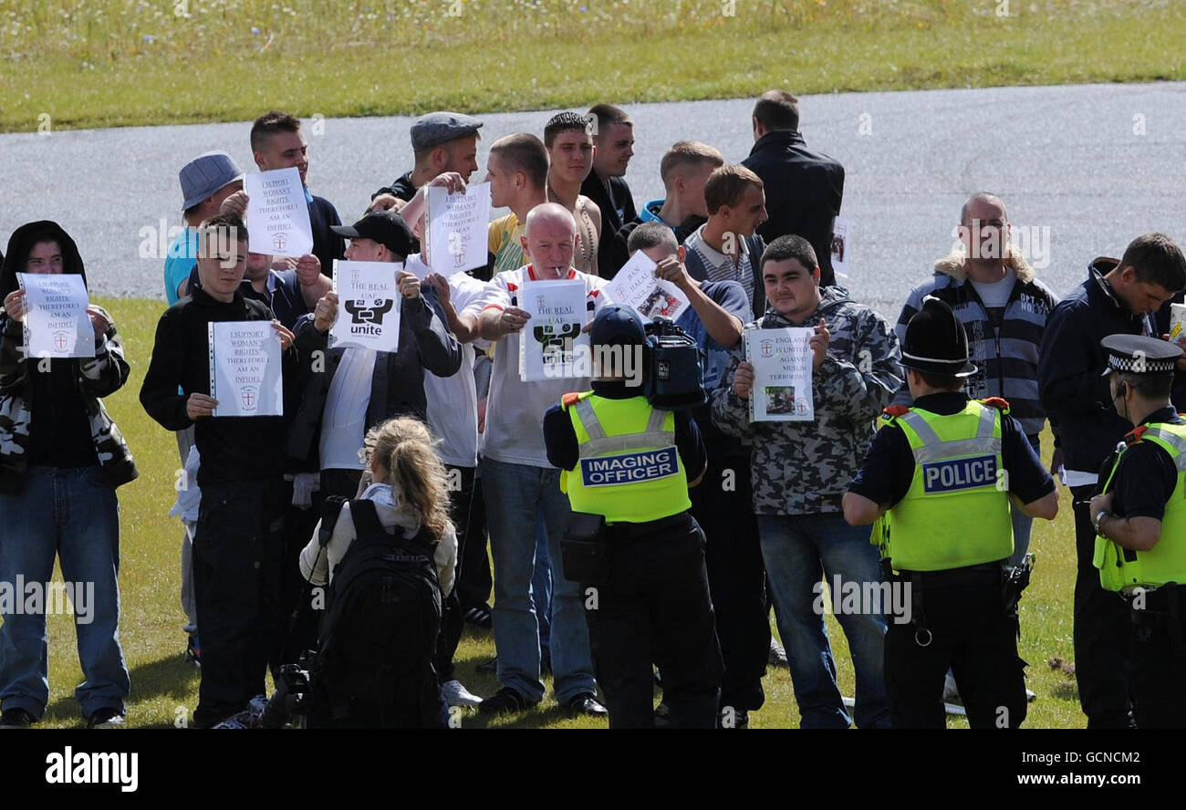 English Defence League (EDL) supporters hold up signs to the Police as ...