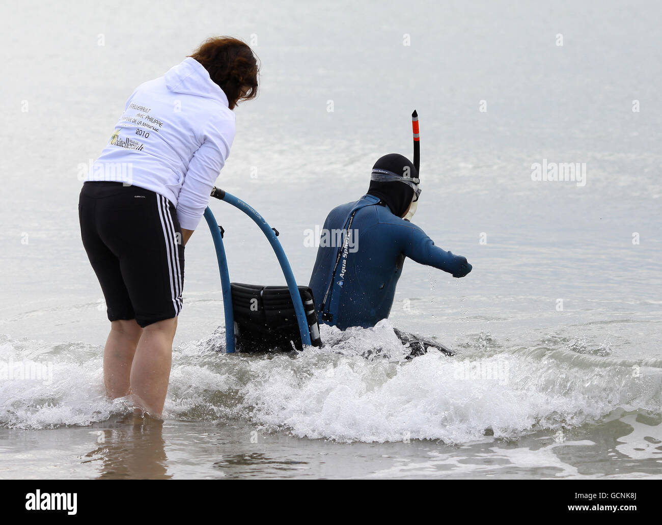 French limbless swimmer Philippe Croizon is helped into the sea by team ...