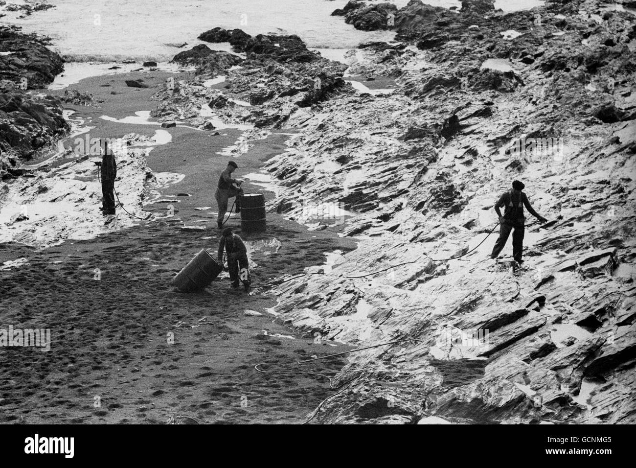 Oil from the tanker Torrey Canyon glistens on rocks as troops spray ...