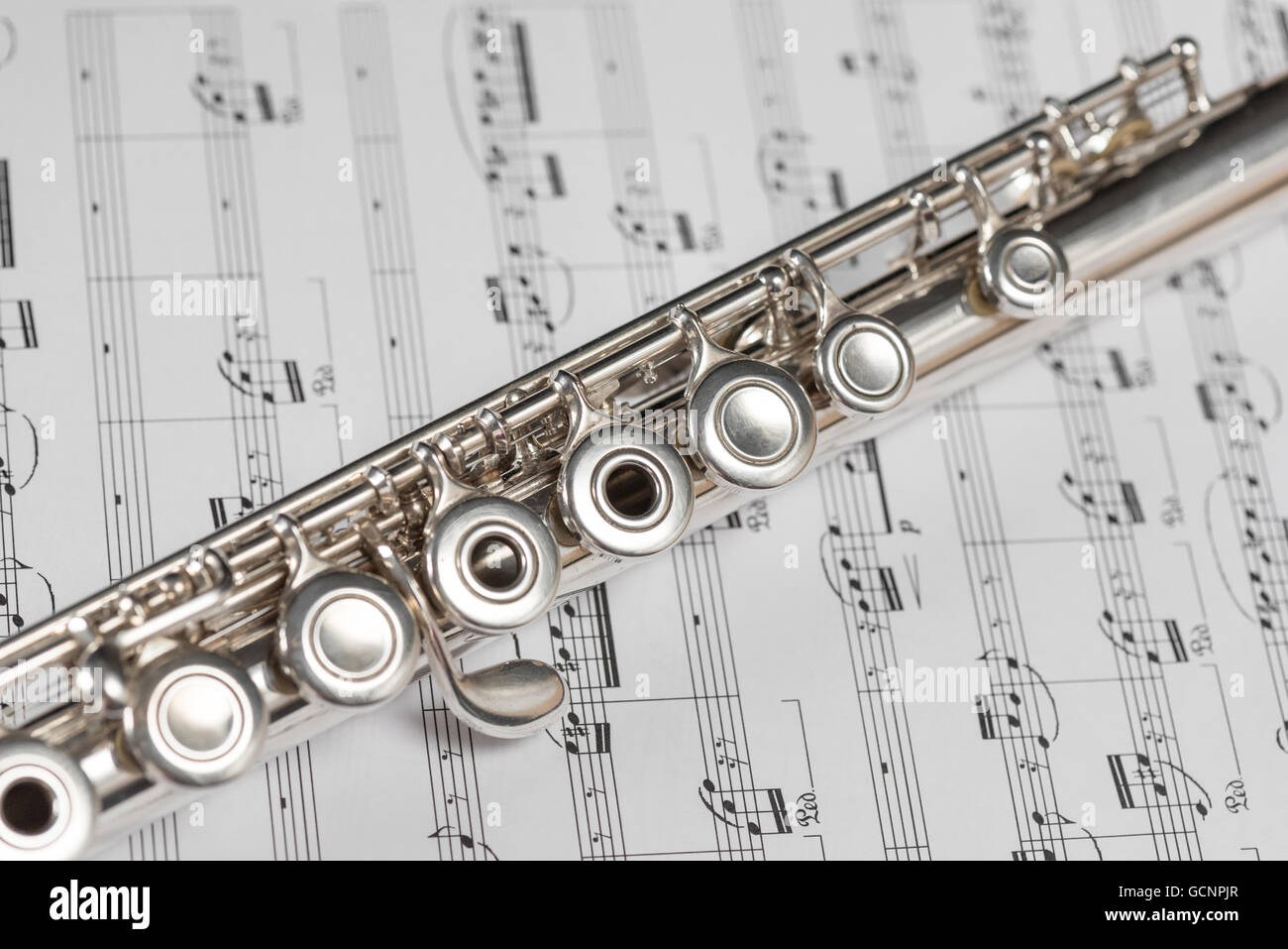 Silver flute on a musical score Stock Photo - Alamy